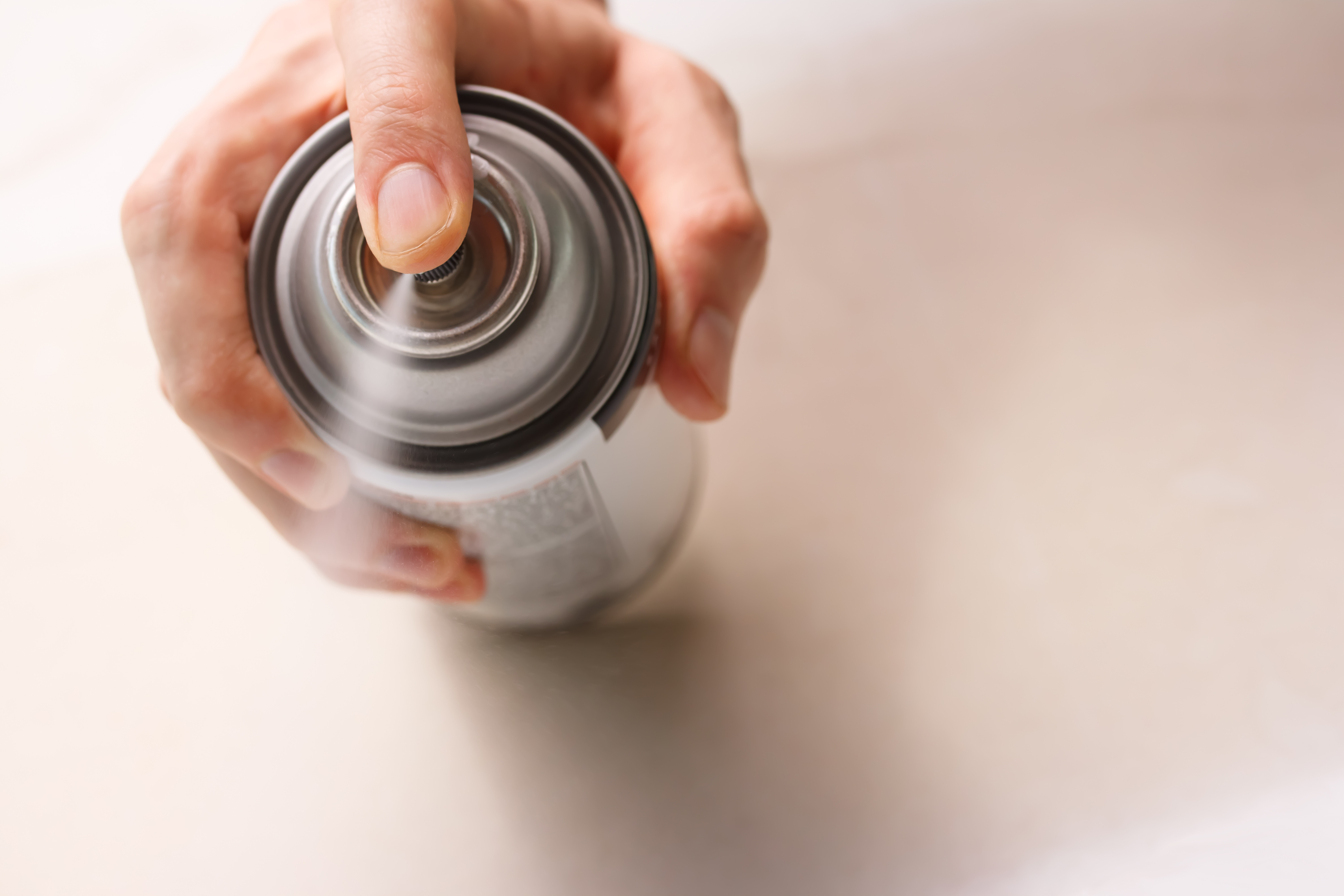 Hand spraying white spray paint - Royal Oil Co.